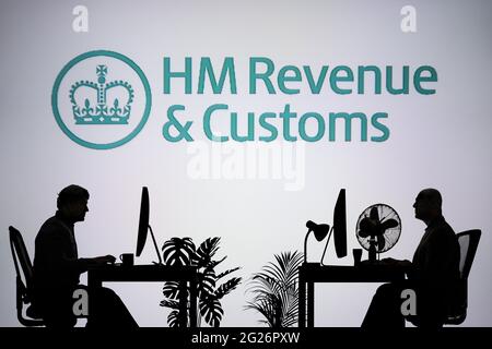 The HMRC logo is seen on an LED screen in the background while a ...