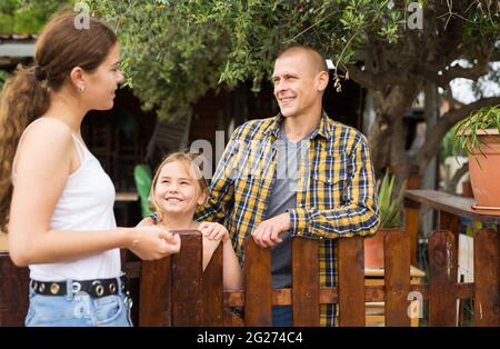 Smiling neighbors talking at backyard garden Stock Photo - Alamy