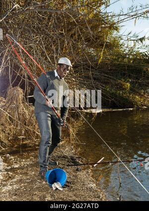 Afro fisherman pulling fish Stock Photo - Alamy