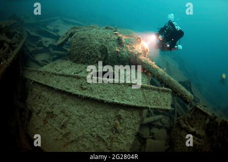 Diver exploring the SS Empire Heritage shipwreck, shown above the winch ...