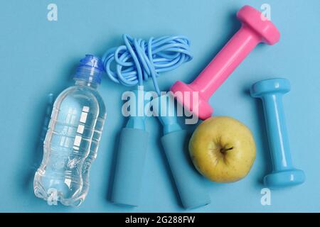Jump rope, apple and barbells next to water bottle Stock Photo - Alamy