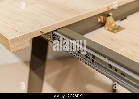 Extendable dinning table. Slide gear close up view Stock Photo - Alamy