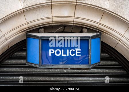 Old fashioned vintage police sign on a globe light hangs on a brick ...