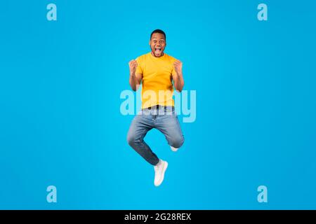 Emotional Black Guy Shouting Gesturing Yes In Mid-Air, Blue Background ...