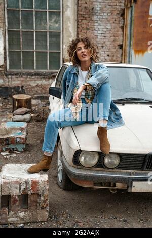 Cheeky modern woman looking at camera while sitting on steps Stock ...