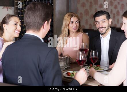 Friendly meeting over dinner with wine in restaurant Stock Photo - Alamy