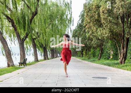 Woman in red dress running away Stock Photo - Alamy