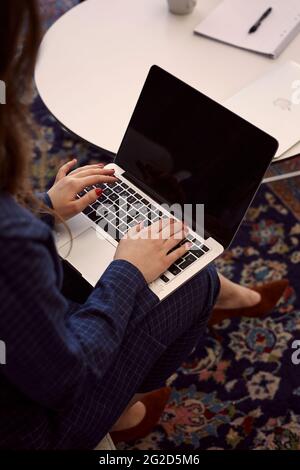 Mid section of a businesswoman using laptop and calculator Stock Photo ...