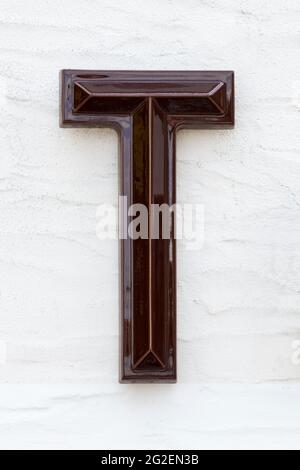 Dark brown glazed letter ü on a light wall Stock Photo - Alamy