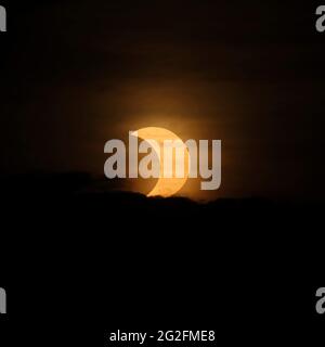 An annular solar eclipse rises over the skyline of Toronto on Thursday ...