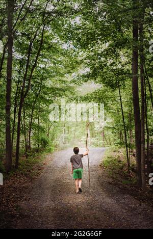Teen boy walking and looking up with headphones isolated on white ...