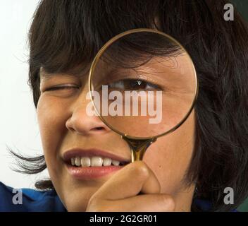 Teen Boy Using Magnifying Glass While Studying Plants In Park Stock ...