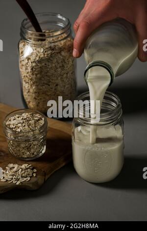 pour oat milk in glass on wood background with copy space, wide photo ...