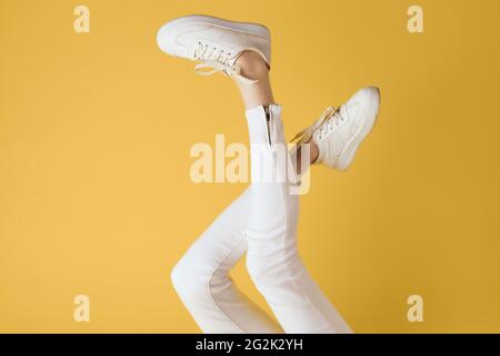 inverted legs in white sneakers fashion modern style yellow background ...