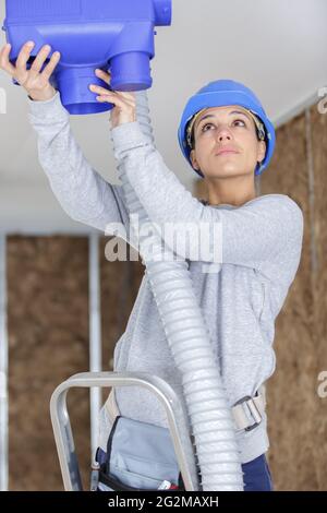 young woman fixing air conditioner in house Stock Photo - Alamy