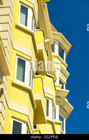 Bright yellow building with deep blue trim wall facade building along ...