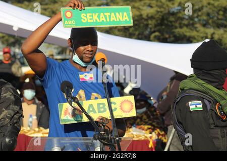 A bodyguard fixes Basotho Action Party leader Nqosa Mahao's face mask ...