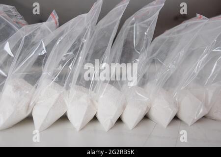 A large number of transparent sachets filled with white powder. White ...