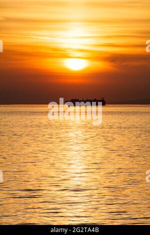 The sun about to disappear behind some cloud cover Stock Photo - Alamy