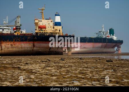 Alang ,01, February, 2016:Small red boat and large ship brought to Alang Ship Breaking Yard for ...