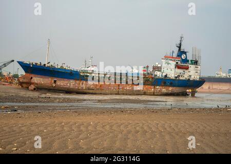 Alang ,01, February, 2016:Small red boat and large ship brought to Alang Ship Breaking Yard for ...