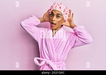 A joyful transgender person with a playful expression peeks through a ...