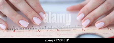 Doctor cardiologist examining electrocardiogram with ruler closeup ...
