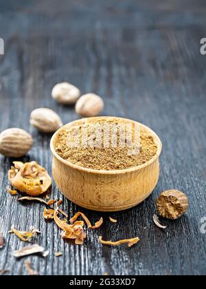 Dried nutmeg arillus and ground nutmeg in two spoons, whole nuts on ...