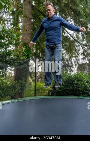 a man jumping on a trampoline and falling isolated Stock Photo - Alamy