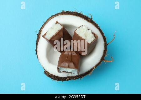 Coconut with candy bars on blue background Stock Photo - Alamy