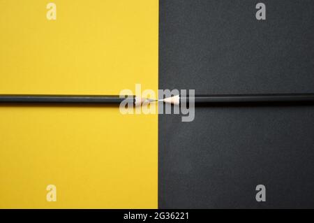 Overhead photo of two black pens pointing toward each other on ...