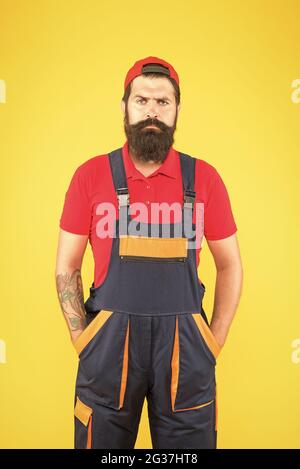 Bearded man, builder, plumber in orange uniform and helmet peeking our ...