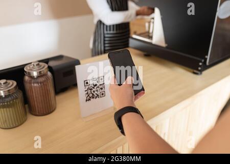 Female customer scanning QR code on label of fresh baked goods in ...