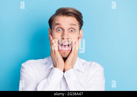 Photo of terrified young man hold arms look interested empty space ...