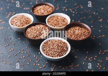 Composition with bowls of flax seeds on color background Stock Photo ...