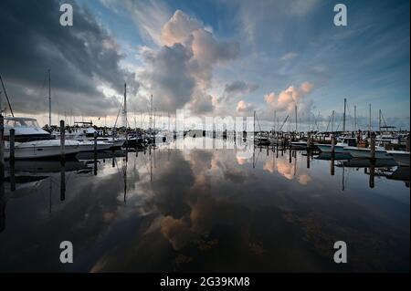 Bright summer cloudscape reflected in tranquil water of Dinner Key ...