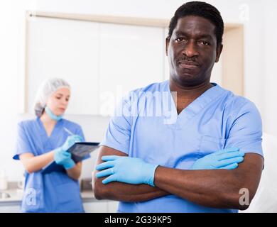 Professional male cosmetician welcoming to aesthetic clinic Stock Photo ...