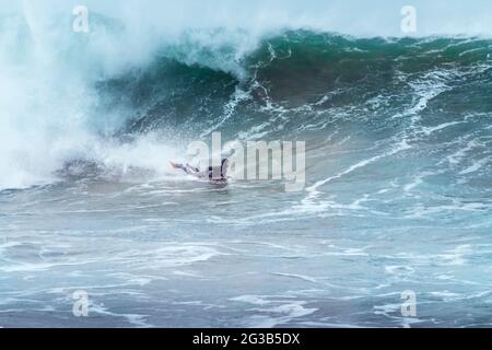 A body boarder riding huge waves building over the Cribbar Reef off the ...