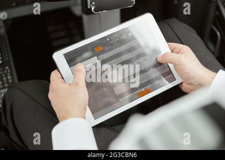 Pilot use digital tablet in passenger airplane jet Stock Photo - Alamy