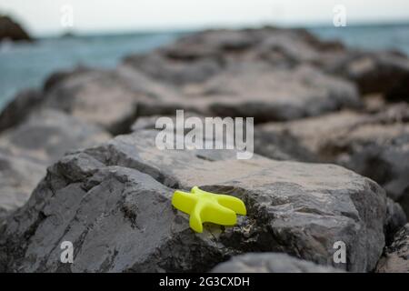 Closeup shot of a plastic starfish on a rock surface on a blurred ...