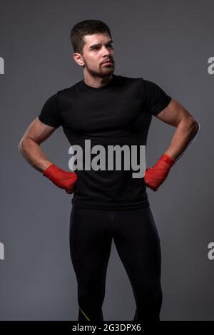 Muscular young man with wrist wraps flexing muscles Stock Photo - Alamy
