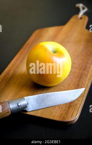 Organic fresh apple and pocket knife on a wooden cutting board Stock ...