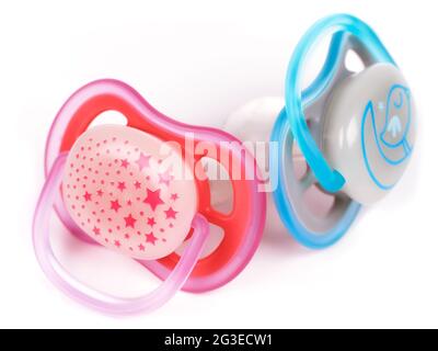Pink and Blue Pacifiers on a white background. Two pacifiers close-up ...