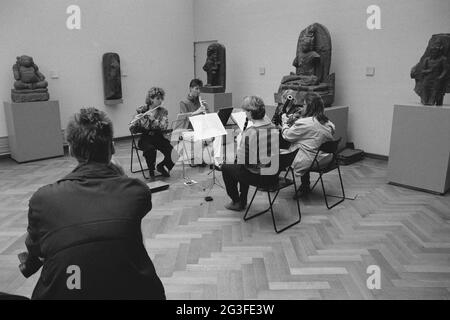 Musicians playing wind instruments while sitting next to images; Music ...