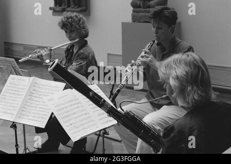Three seated musicians play bladder instruments; Music weekend Stock ...