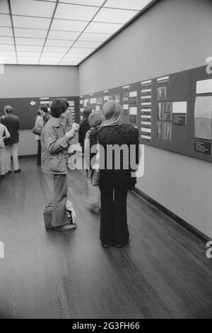 Group of visitors reads information panels on the wall; Educational ...