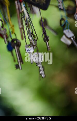Old keys hanging on strings. One key in the middle is in spotlight ...
