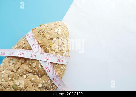 slice of whole meal bread and measurement tape on table Stock Photo - Alamy