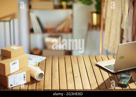Workplace with laptop and parcels in office Stock Photo - Alamy