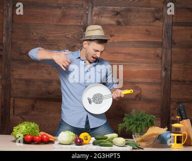 man cooking salad on the pan on grunge background Stock Photo - Alamy